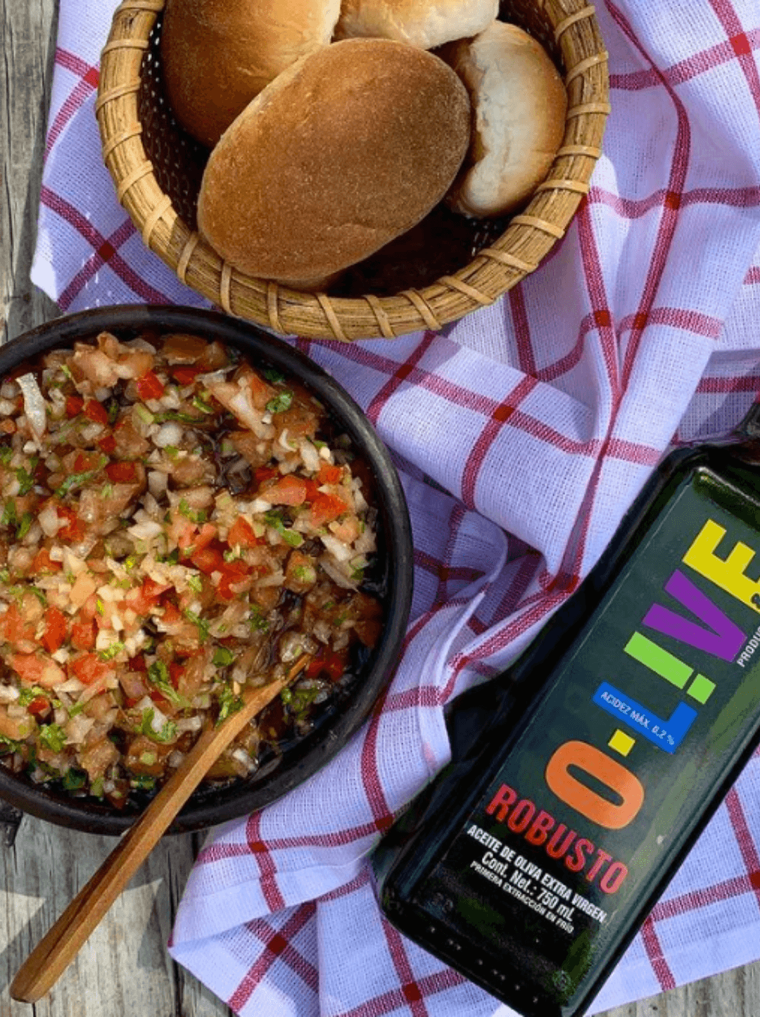 Dos fuentes de greda con pebre chileno junto a una botella de aceite de ...